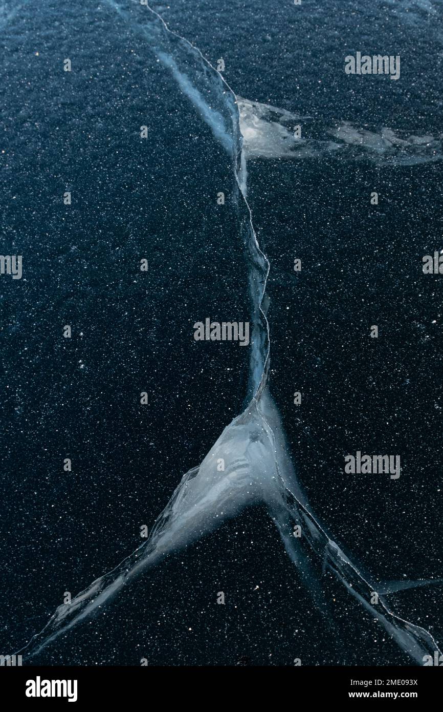 Natural blue ice on the lake. Beautiful winter landscape. Cracks in the ...