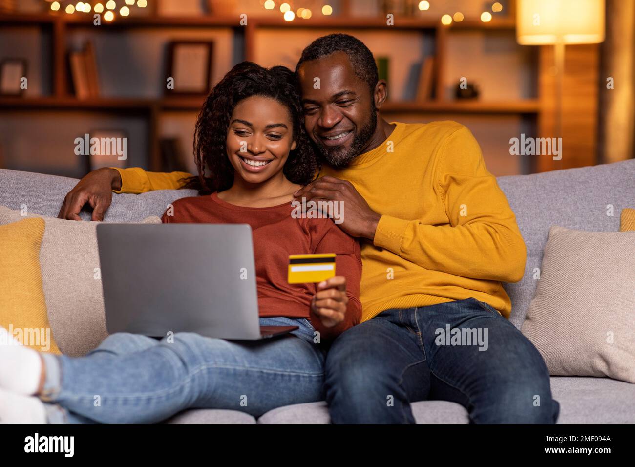 Happy black couple banking from home, using laptop, credit card Stock ...