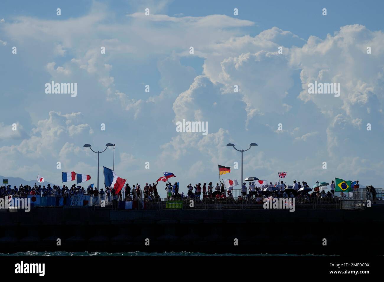 Team members watch from the harbor dock of Enoshima the women's 470 ...