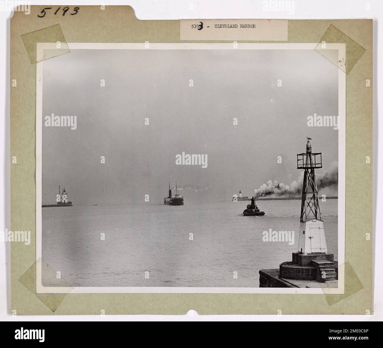 An ore carrier enters Cleveland Harbor, guided by three navigational ...