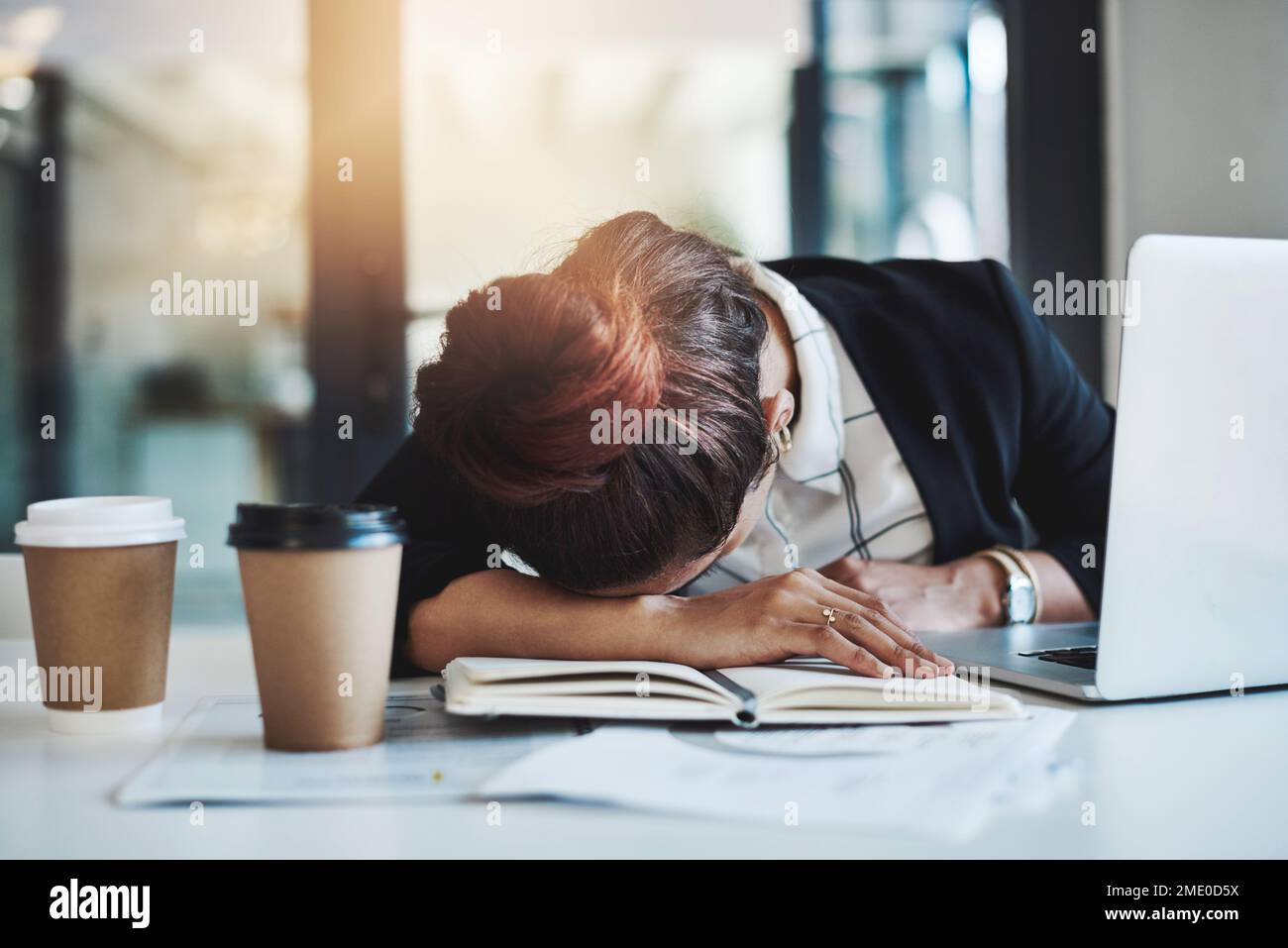 I give up. a young businesswoman sleeping at her desk in a modern ...