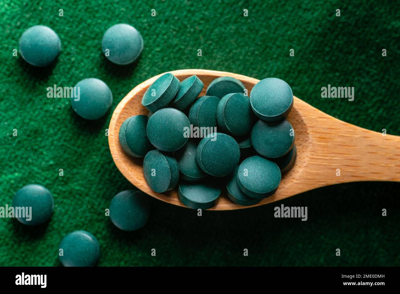 Green Organic Spirulina in algae pills tablets bamboo wood spoon rich ...