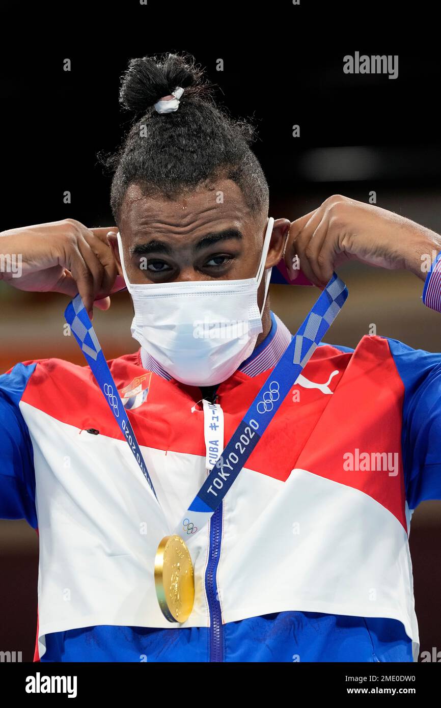 Arlen Lopez, of Cuba, places his gold medal around his neck during the ...