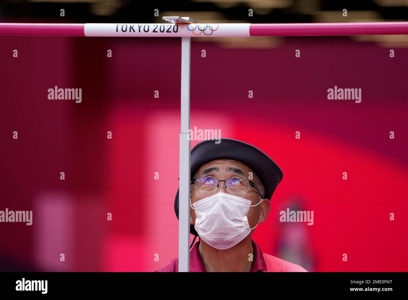 A track official adjusts the height of the bar for the high jump of the ...
