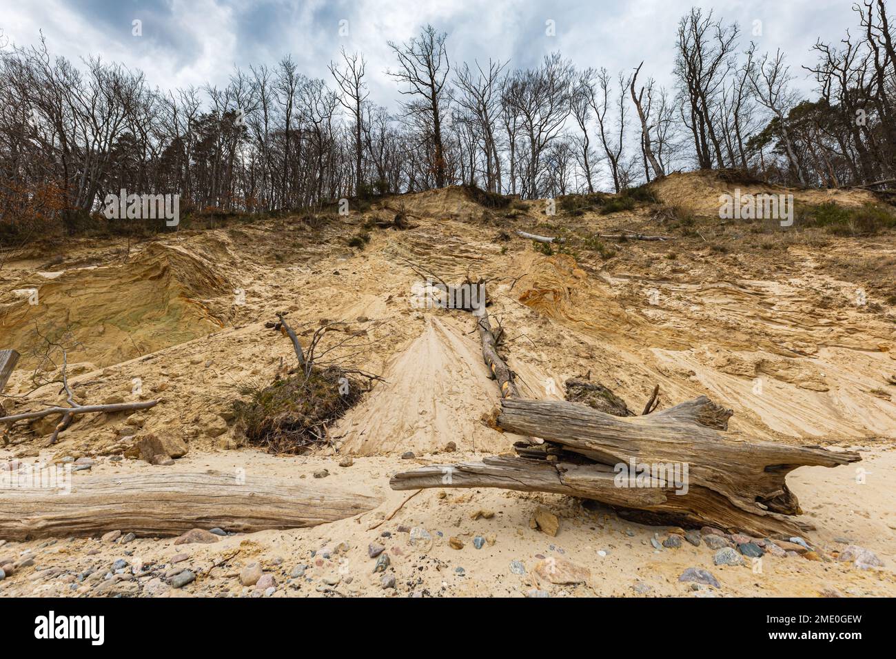 Looking up to high sandy and stony cliff next to the beach Stock Photo ...