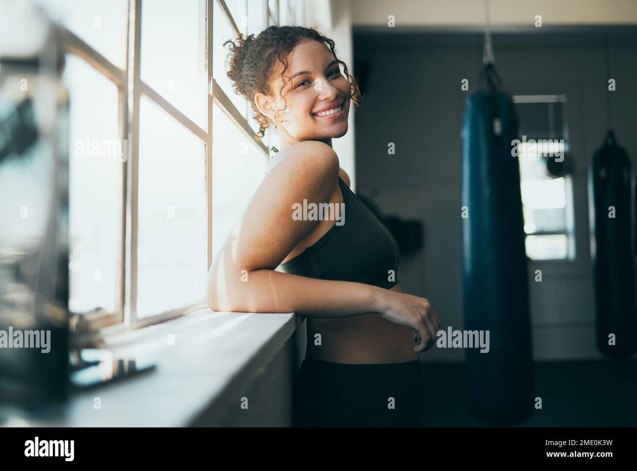 Portrait, window and woman with smile, fitness and workout for wellness ...