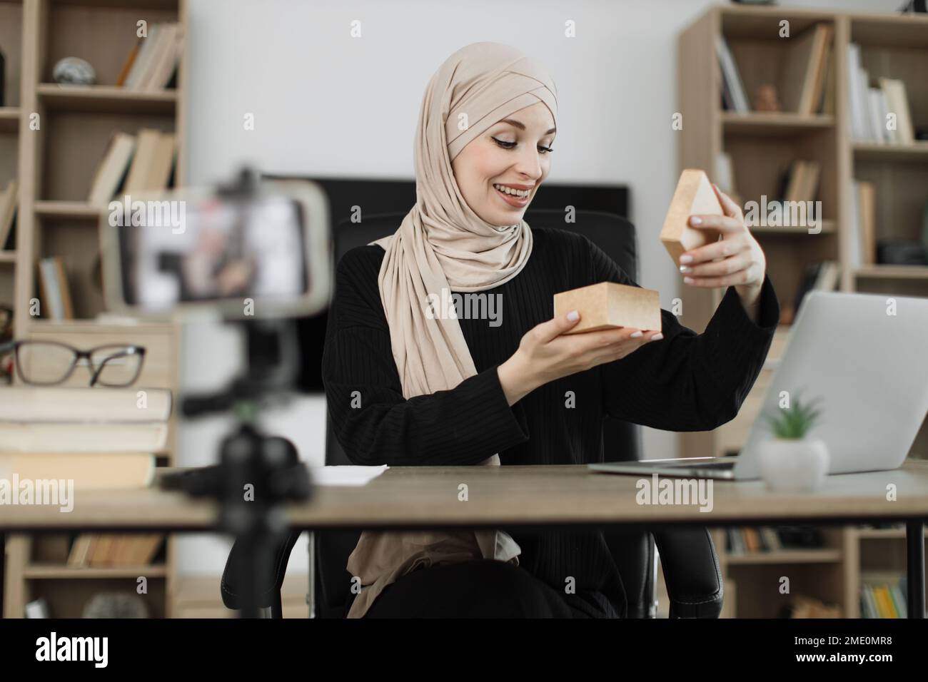 Happy muslim female blogger unpacking gift boxes presents from ...