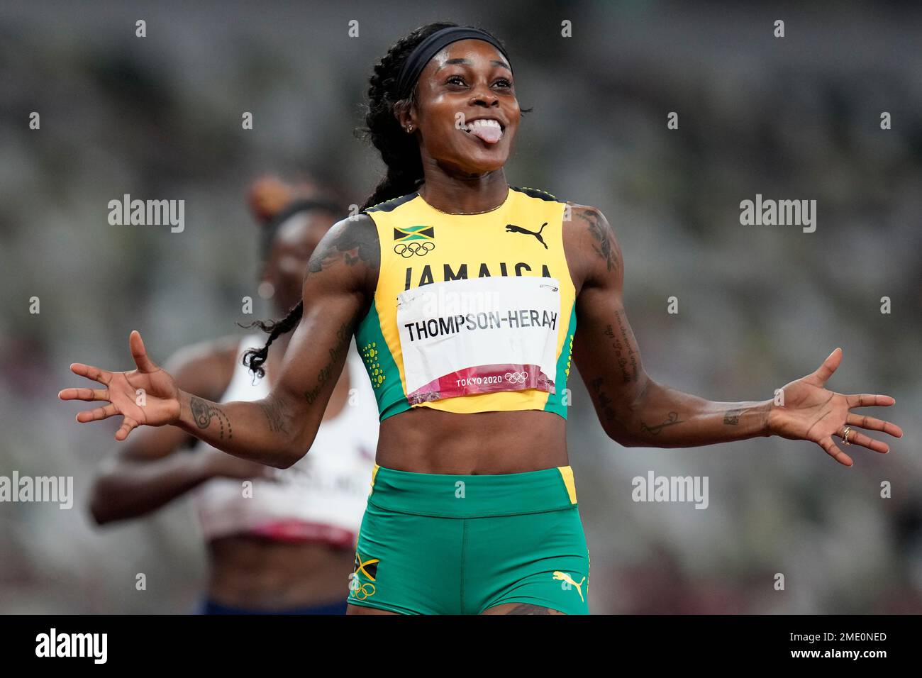 Elaine Thompson-Herah, of Jamaica, celebrates as she crosses the finish ...