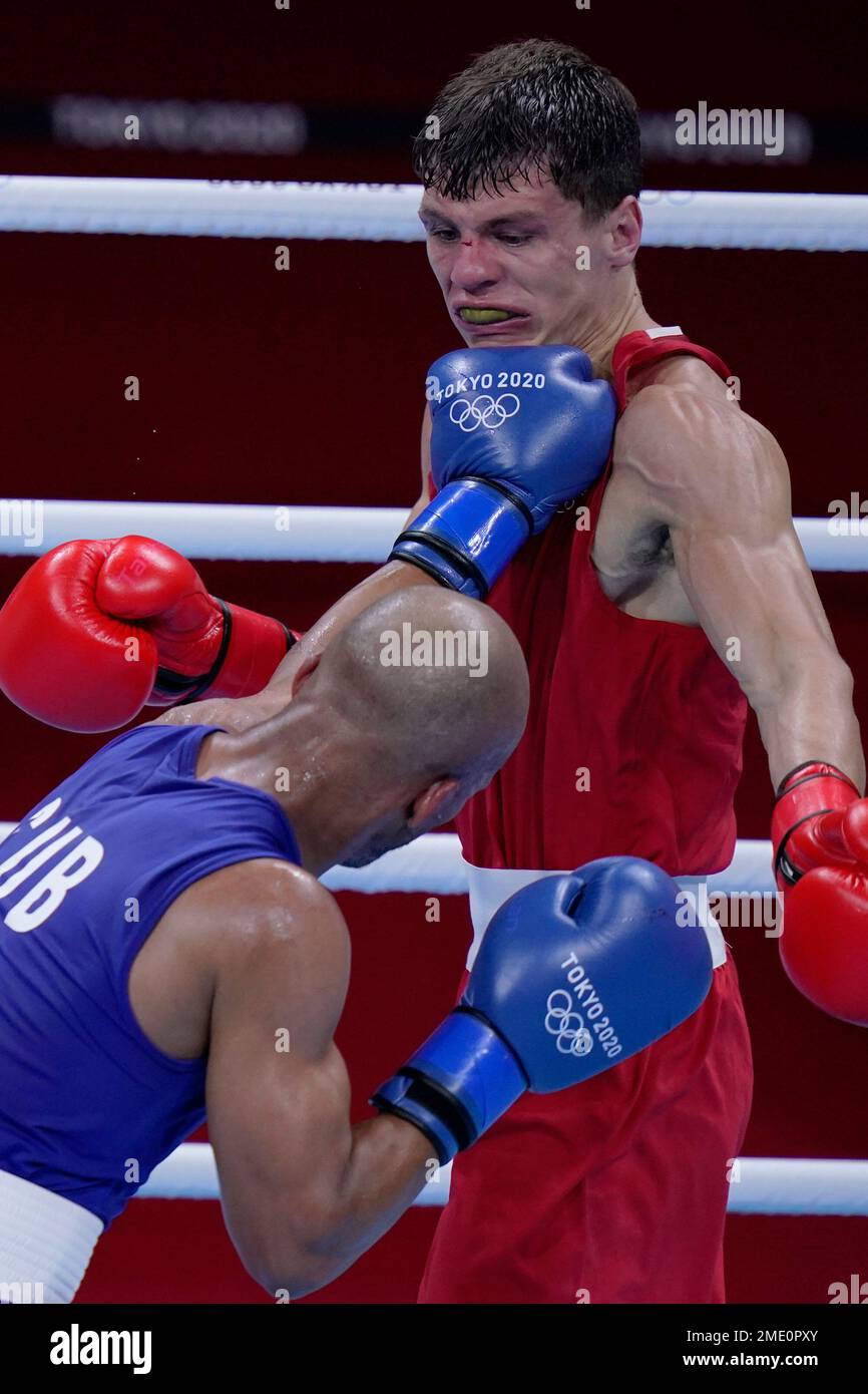 Britain's Pat McCormack,top, takes a punch from Cuba's Roniel Iglesias ...