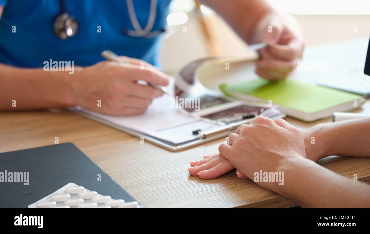 Doctor checking patient ultrasound scan results at his desk Stock Photo ...