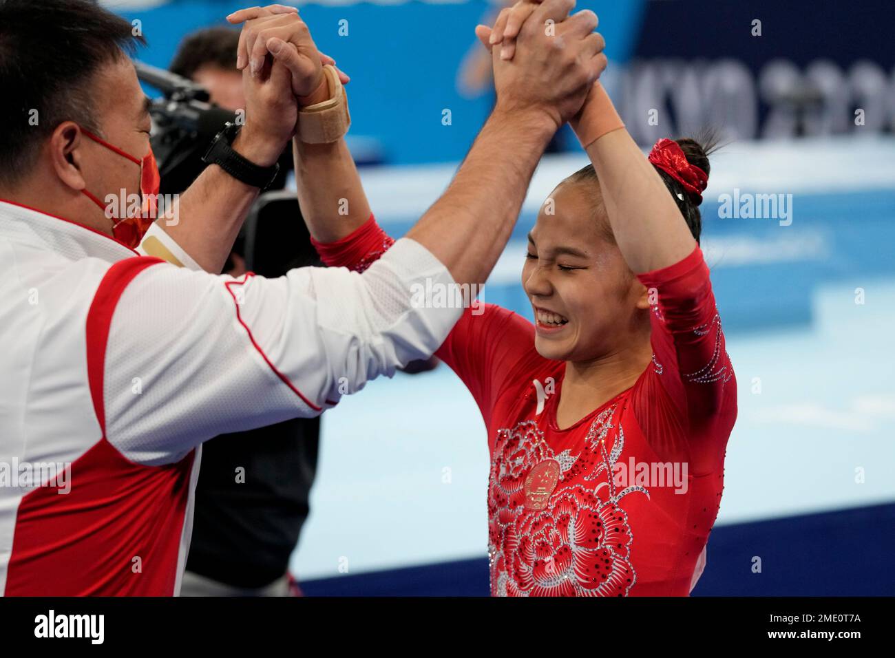 Tang Xijing, of China, celebrates with her coach after performing on ...