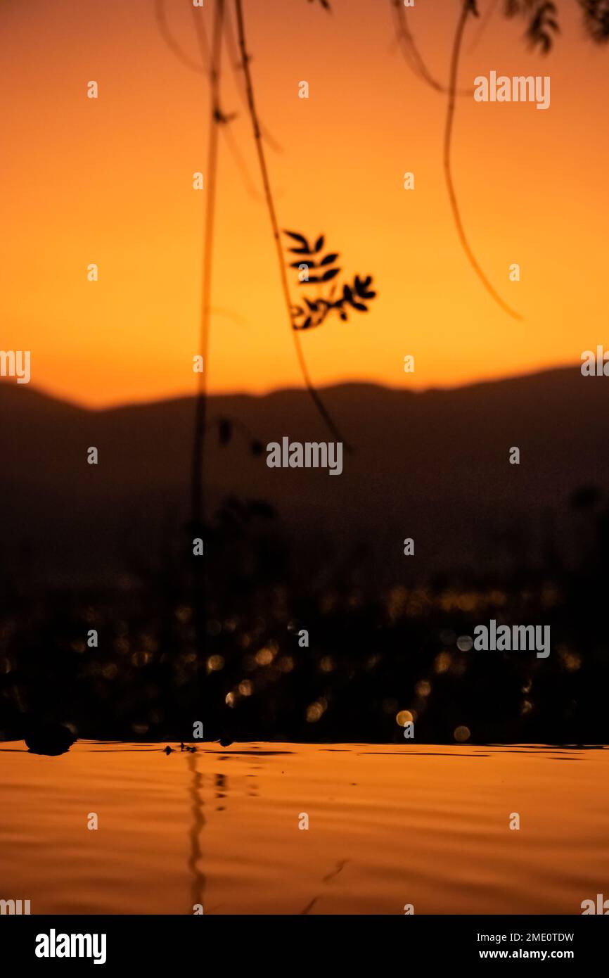 firey sunset reflection above a city Stock Photo - Alamy