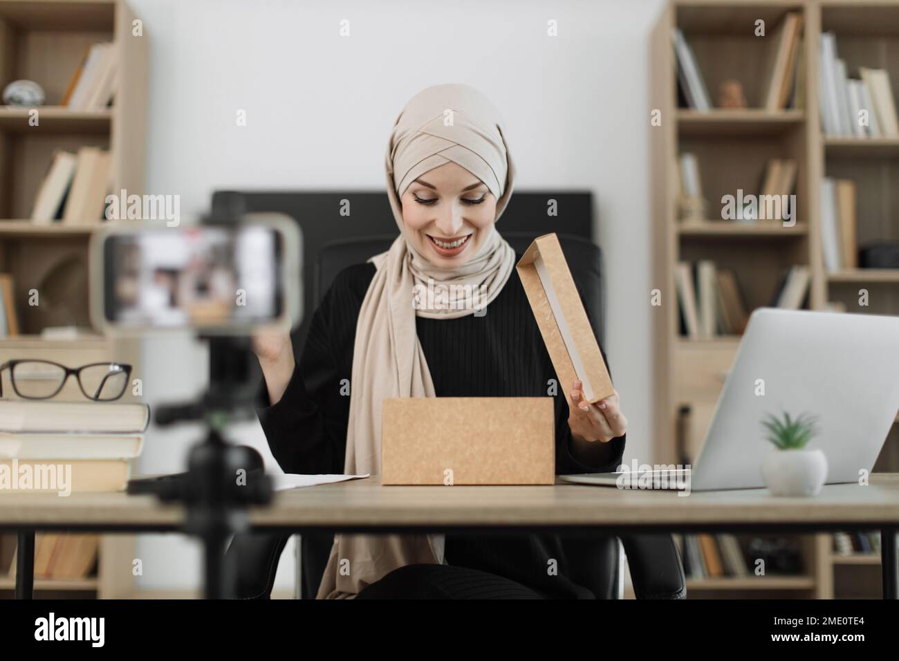 Happy muslim female blogger unpacking gift boxes presents from ...