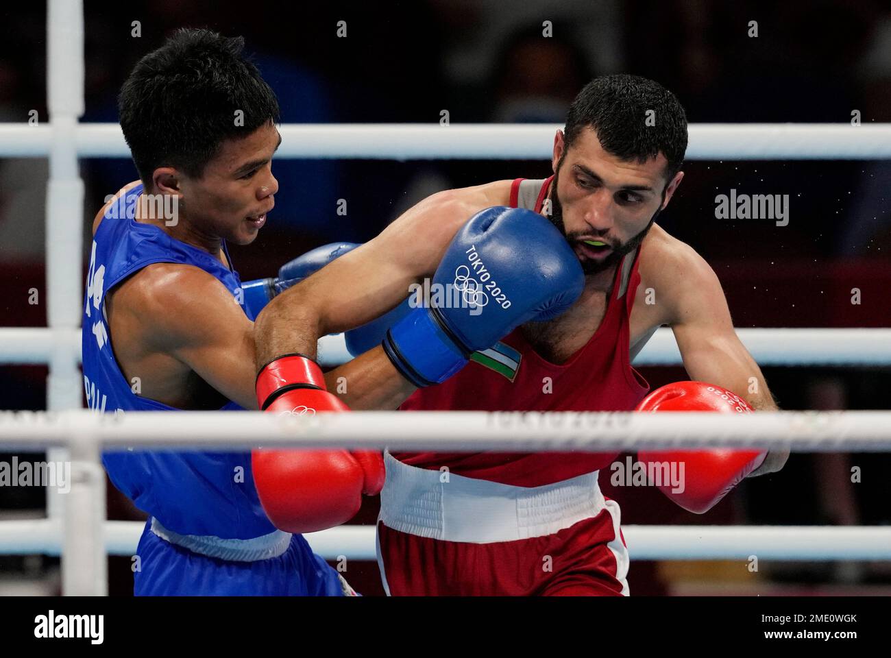 Philippines' Carlo Paalam, left, punches Uzbekistan's Shakhobidin ...