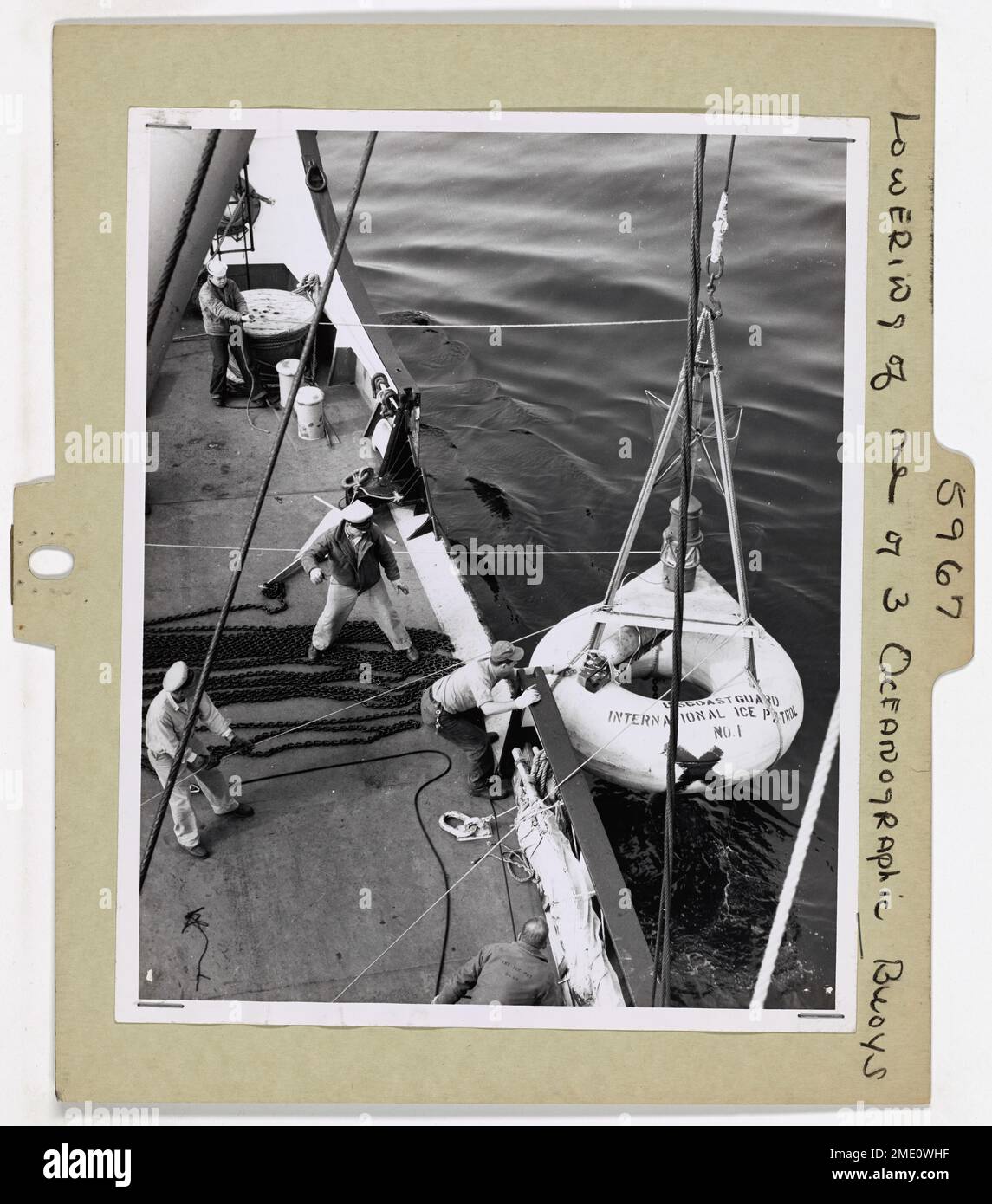A Coast Guard Cutter Evergreen lowers an oceanographic buoy into the ...