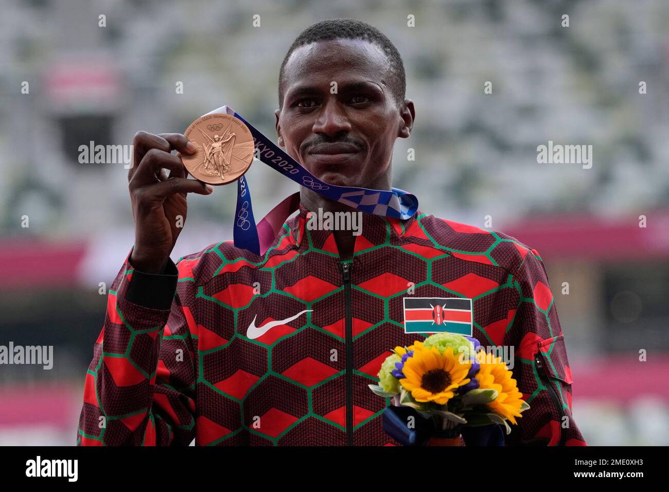 Benjamin Kigen, of Kenya, holds his bronze medal on the podium for the ...