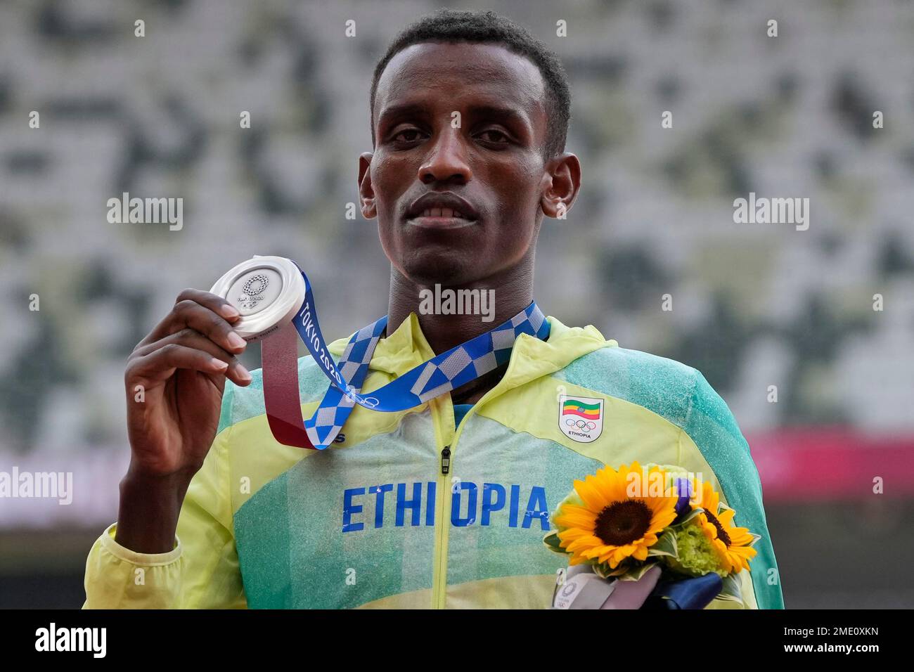Lamecha Girma, of Ethiopia, holds his silver medal on the podium for ...