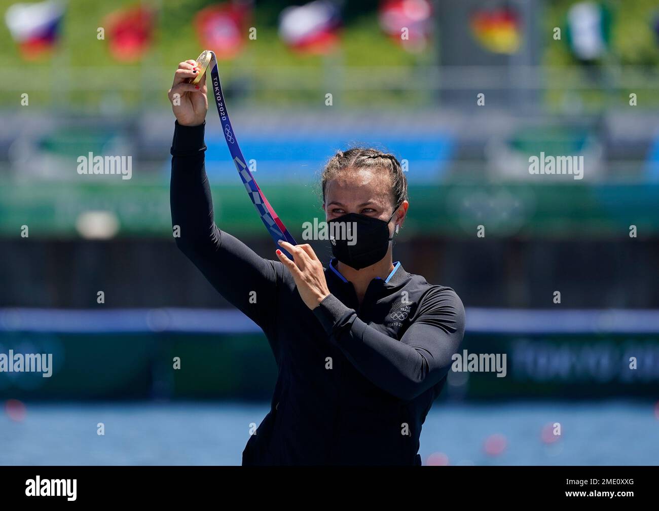 Lisa Carrington of New Zealand holds up the gold medal after winning ...