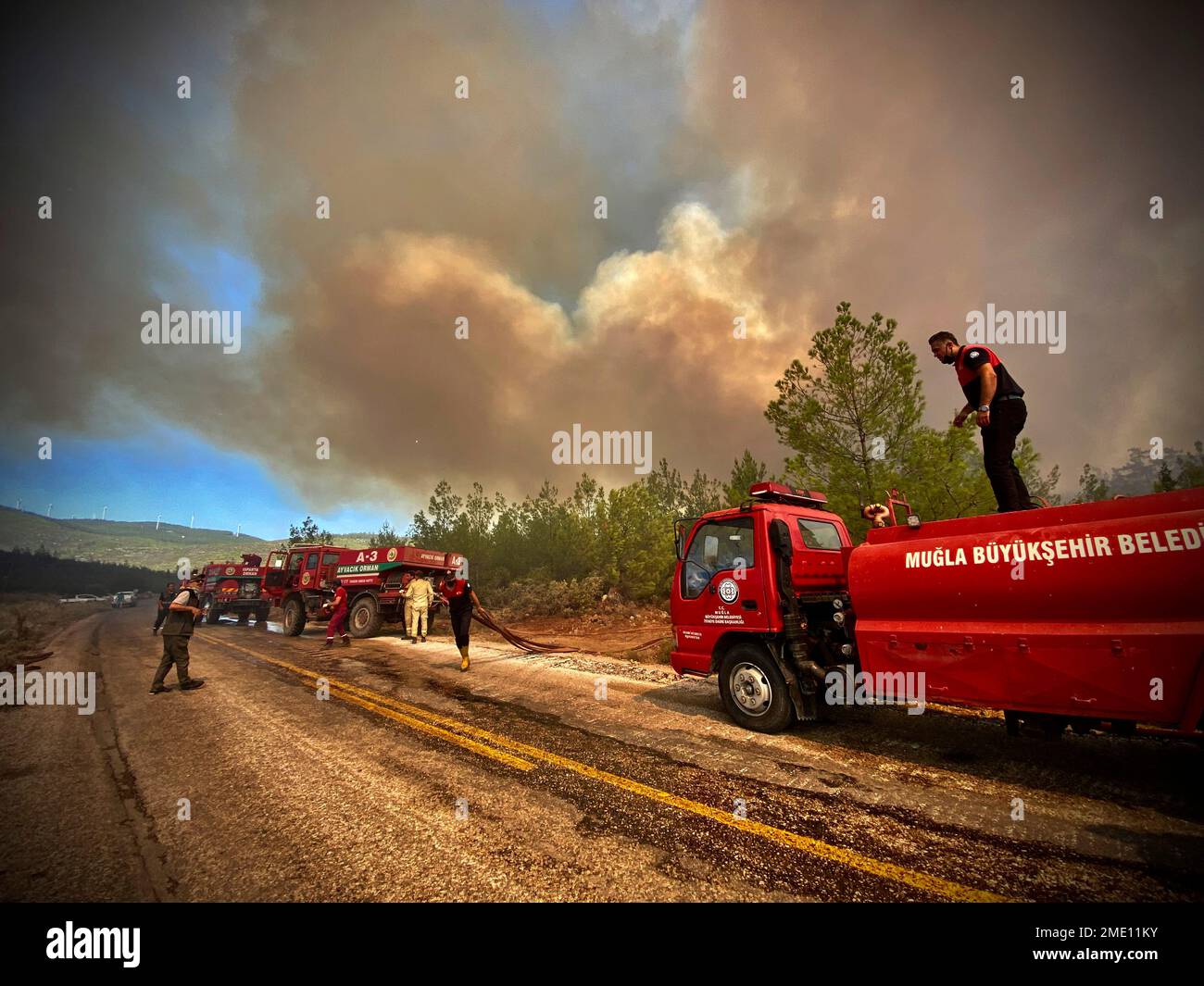 Firefighters work to extinguish an advancing fire, near Bodrum, Turkey ...