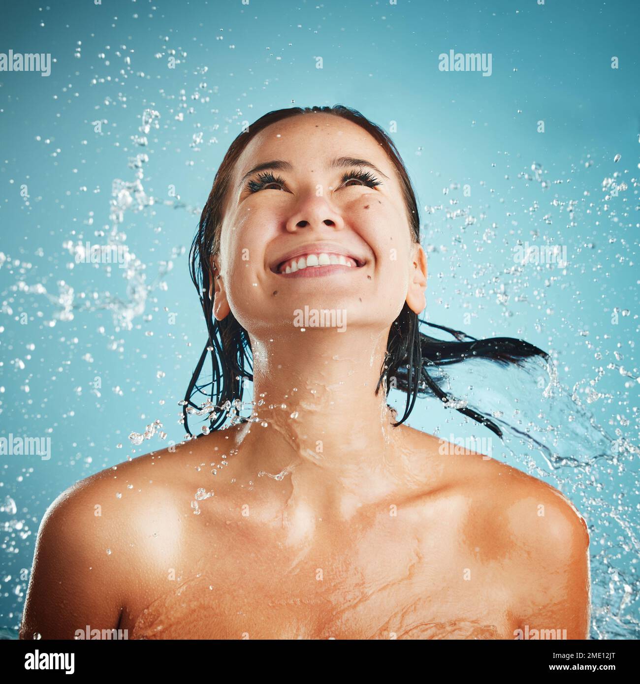 Woman, water splash and happy skincare or luxury body wellness treatment. Young Asian girl smile ...