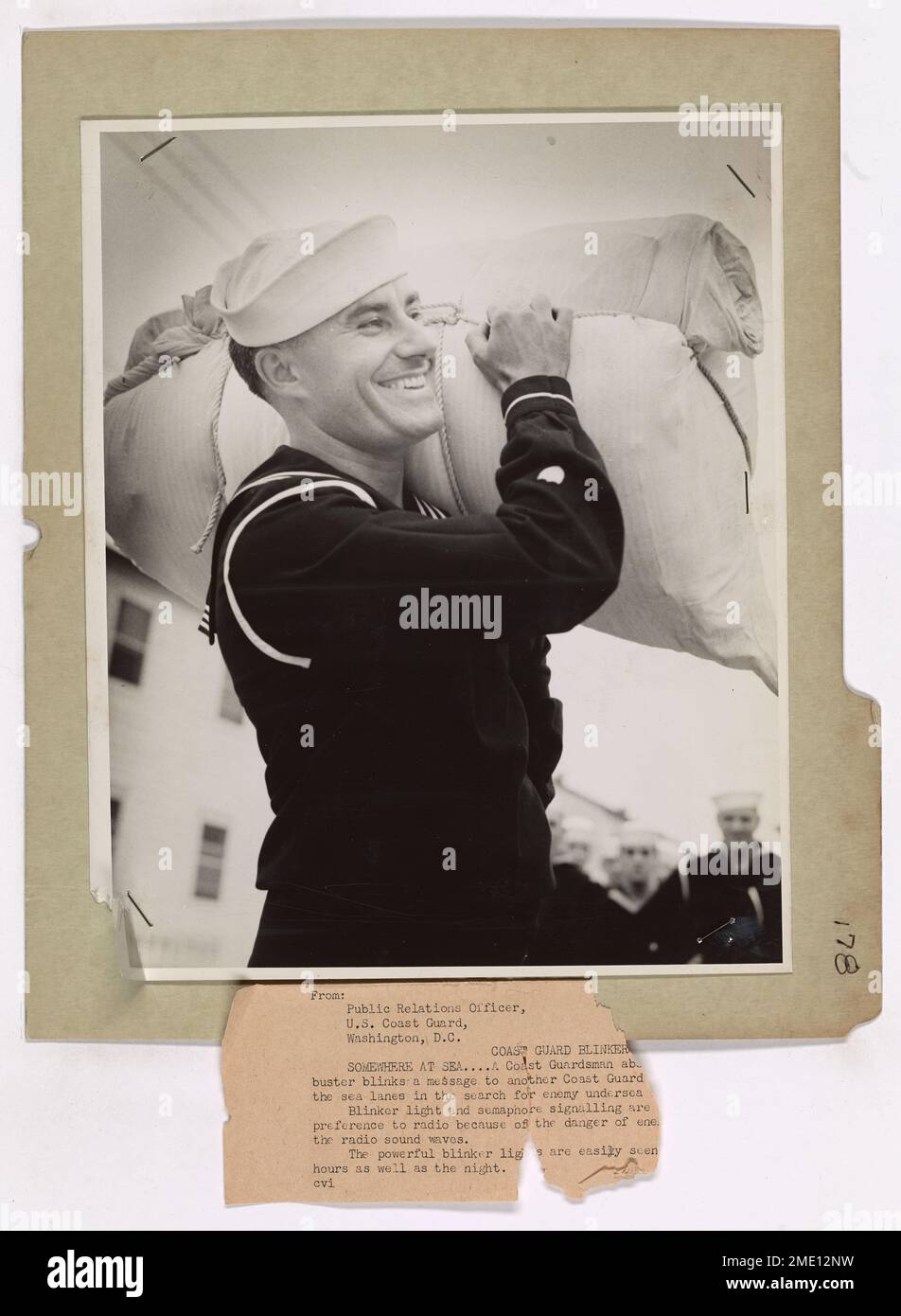 A U.S. Coast Guardsman is shown operating a Coast Guard blinker, an ...