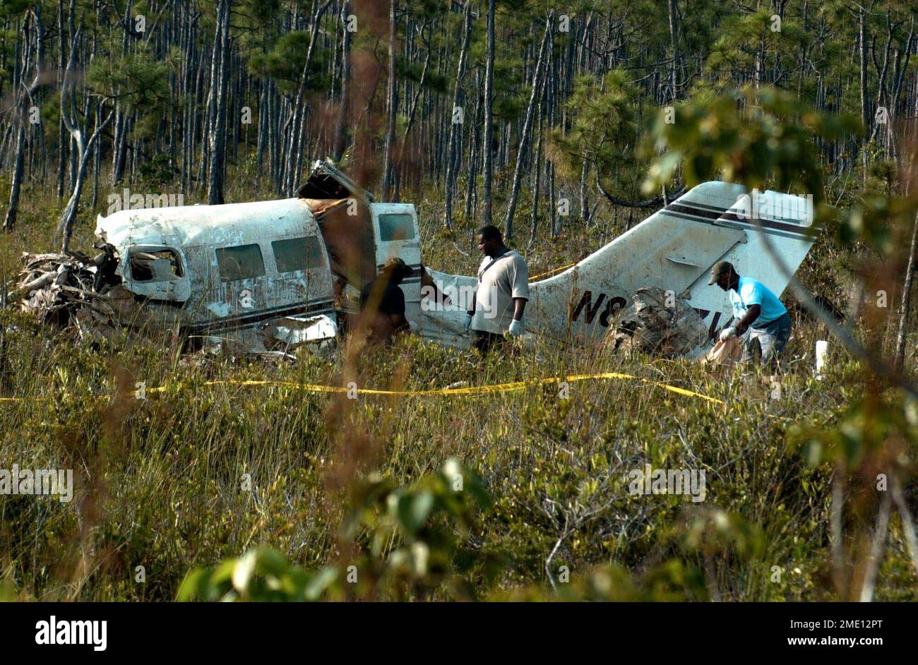 Crash investigators inspect the wreckage Sunday Aug. 26, 2001, in which ...