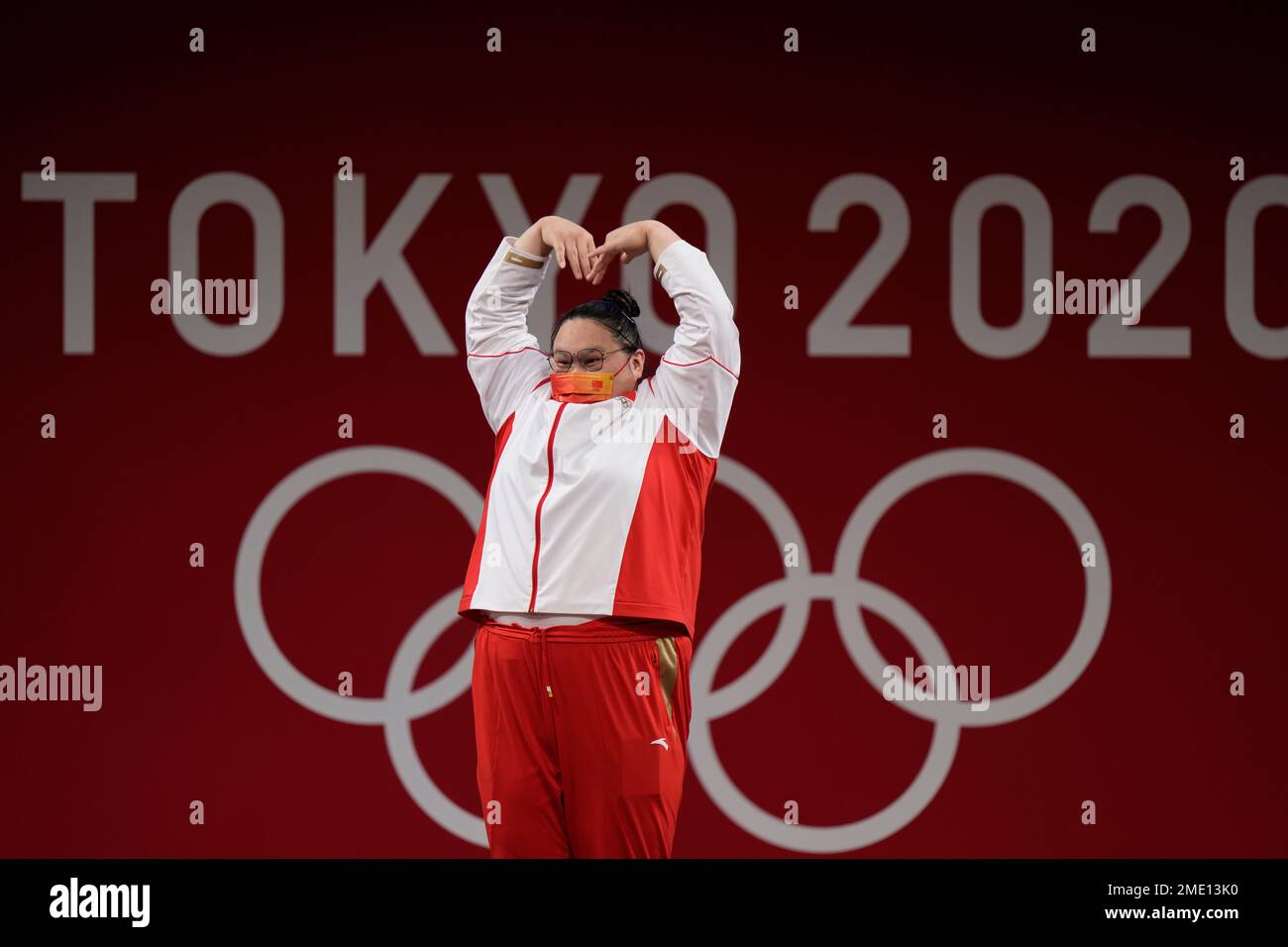 Li Wenwen of China makes a heart with her hands as she takes the podium ...