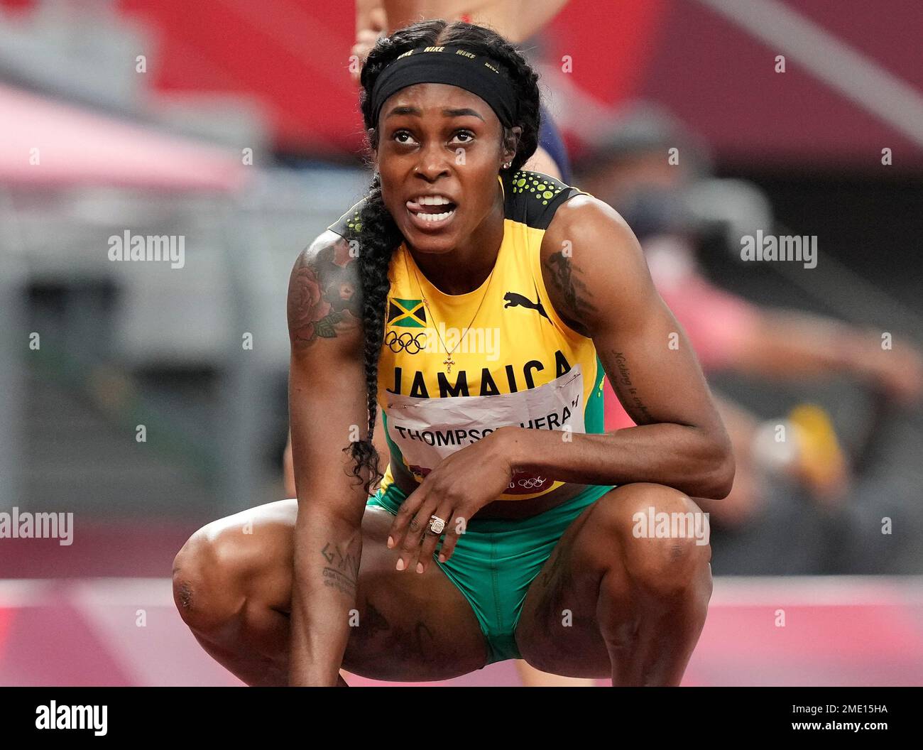 Elaine Thompson-Herah, of Jamaica rests on the track after competing in ...