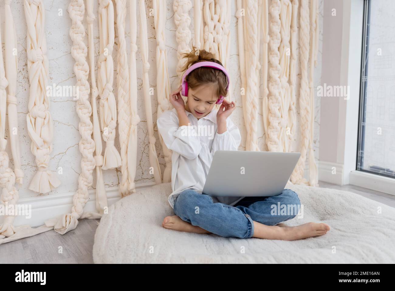 Caucasian funny child kid in headphones, sitting with computer, laptop ...