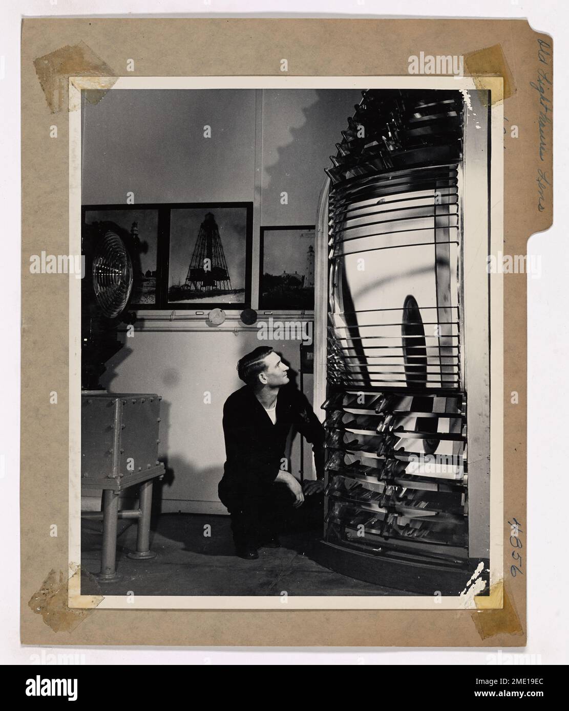 A Coast Guardsman examines an old lighthouse lens, part of a program ...