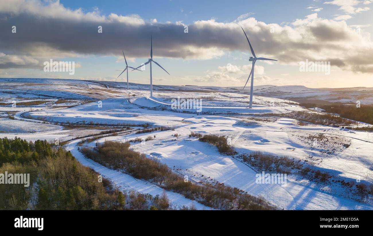 Aerial view of wind turbines on a snow covered hillside in Wales (Bryn ...