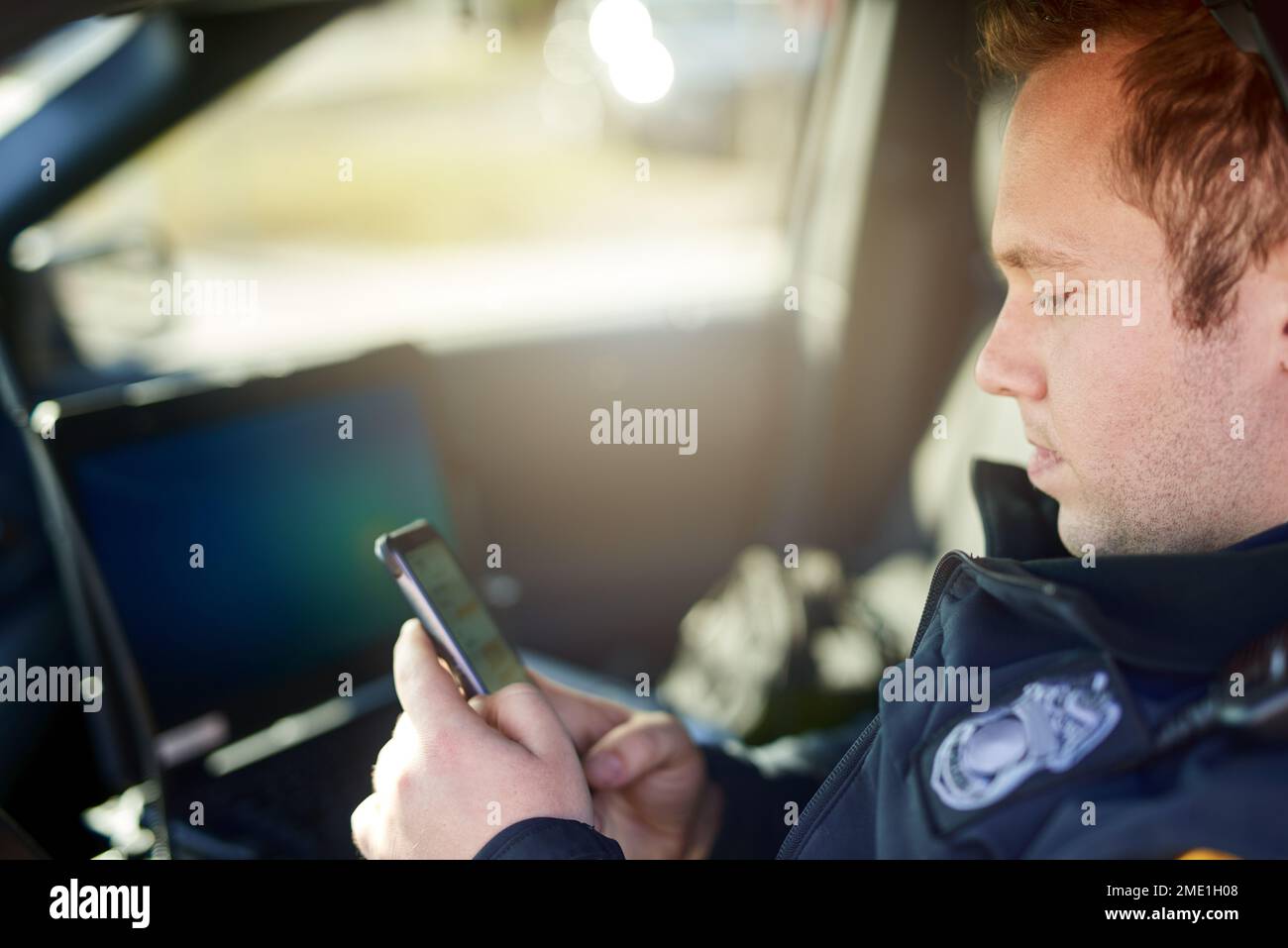 Checking the news. a handsome young male police officer using his ...