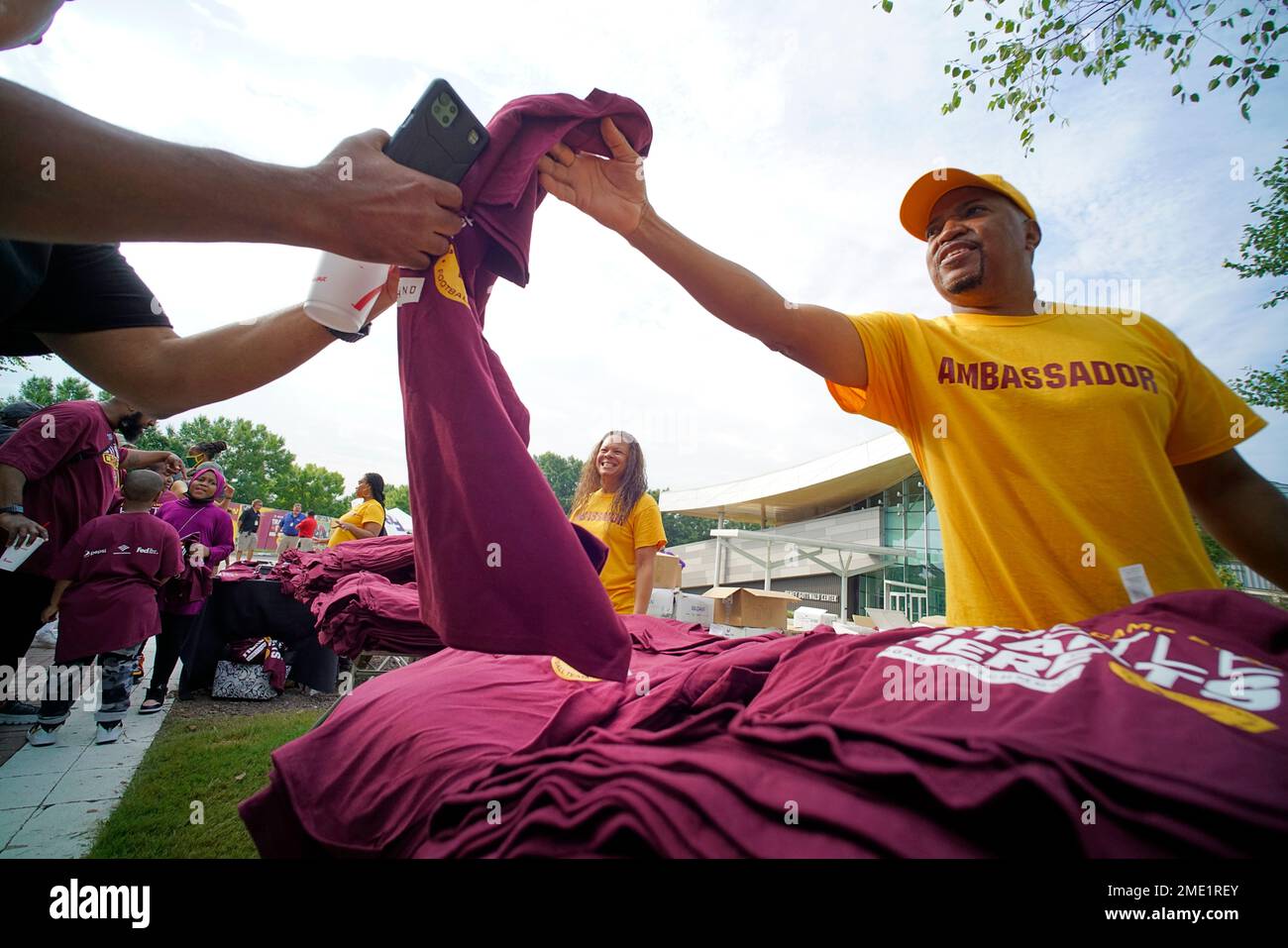 Morris Hunlen, right, hands out free T-shirts during the Washington Football Team's NFL football ...