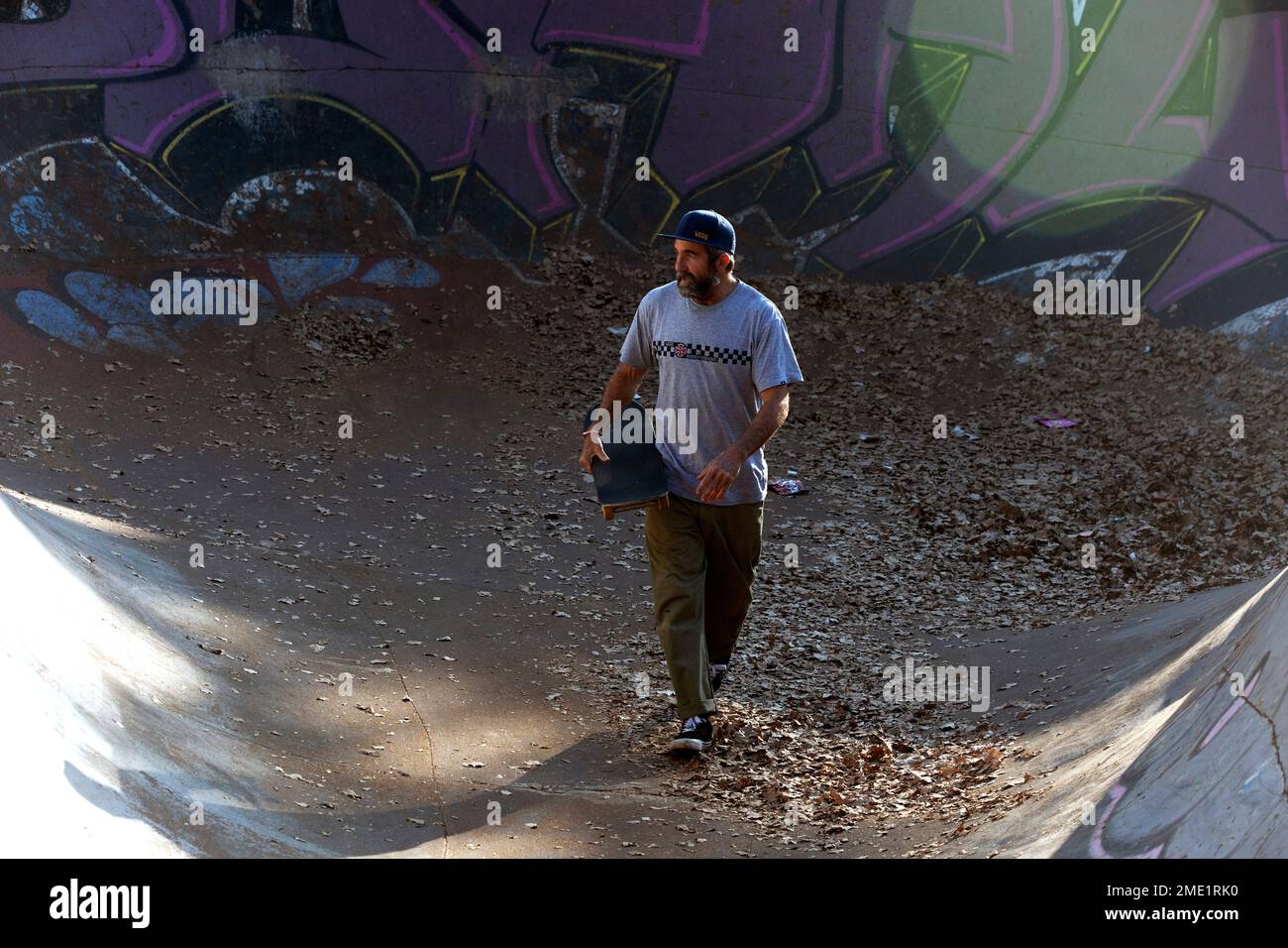 Skateboarder Dallas Oberholzer, 46, walks with his skateboard at at the ...