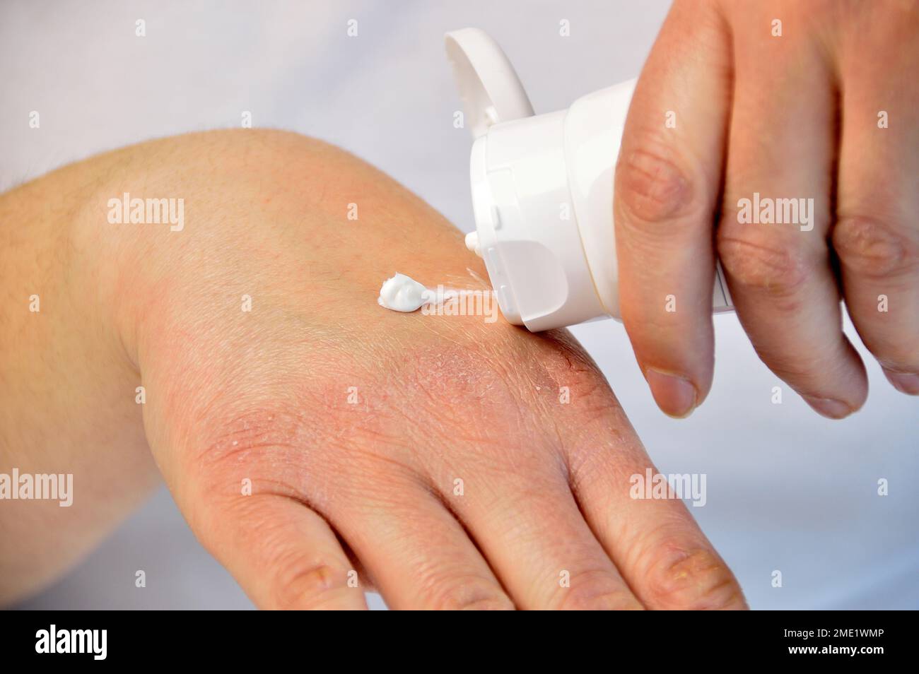 Cropped image of a young woman putting moisturizer onto her hand with ...