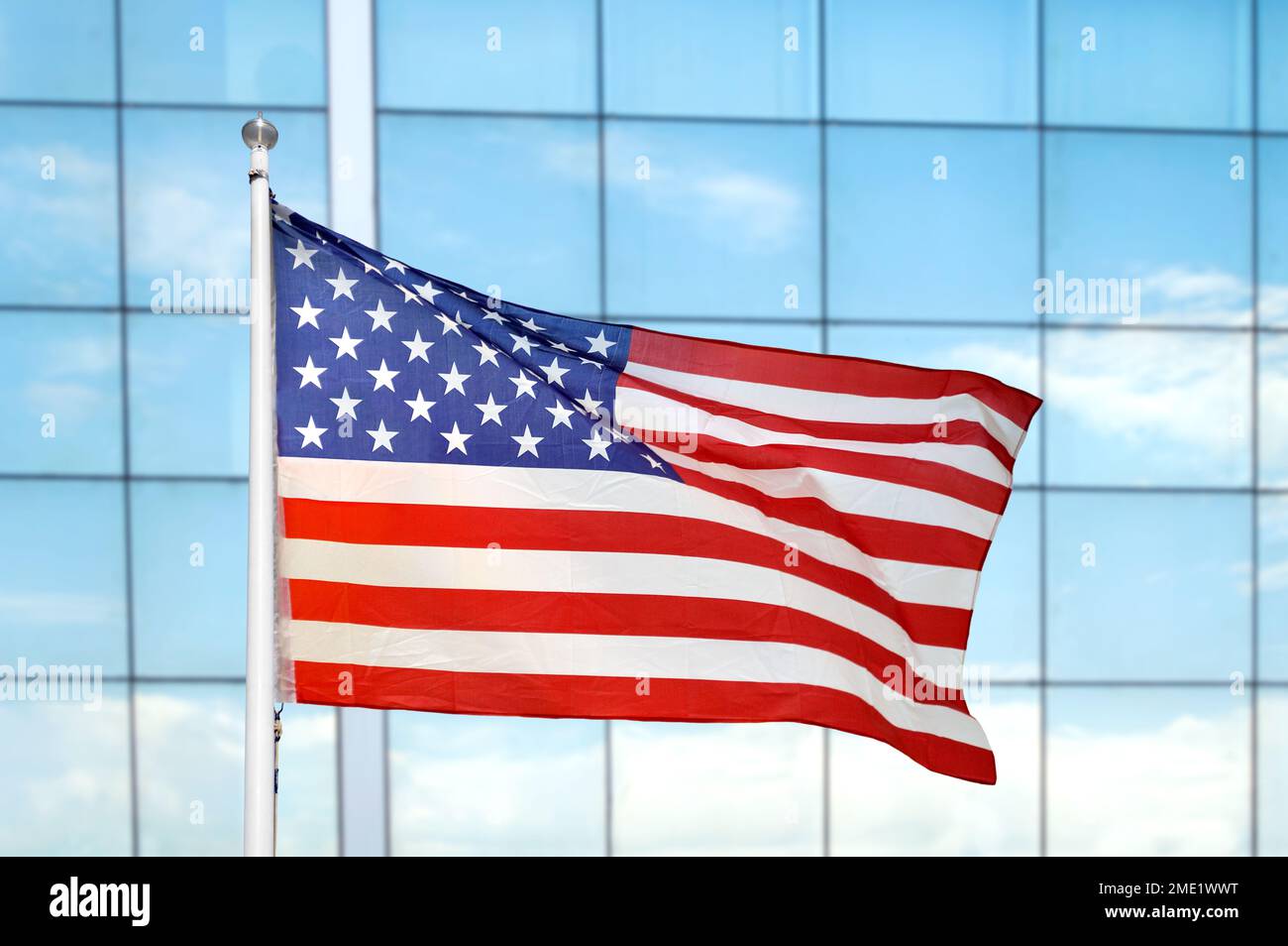 Floating American flag in front of office building sun flare Stock ...
