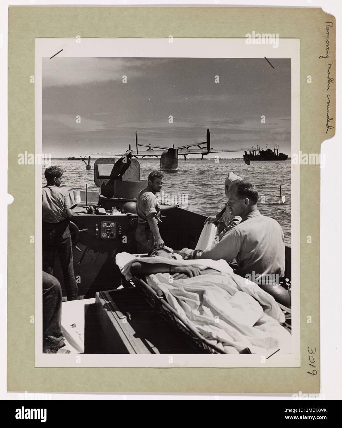 This photograph shows Coast Guardsmen transferring severely wounded ...