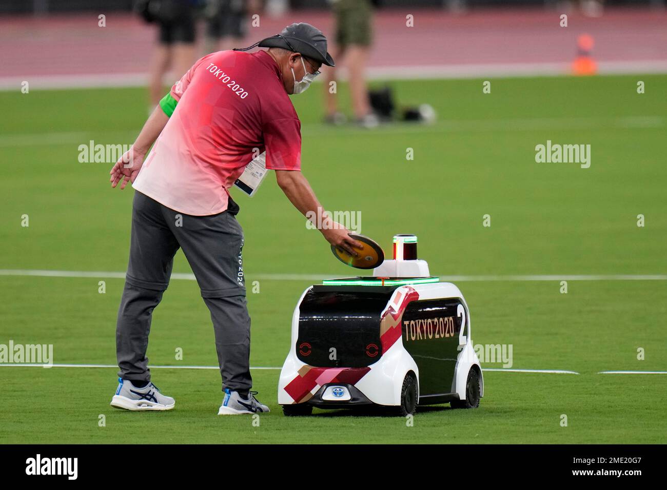 A track official puts a discus disk on motorized cart during the final ...