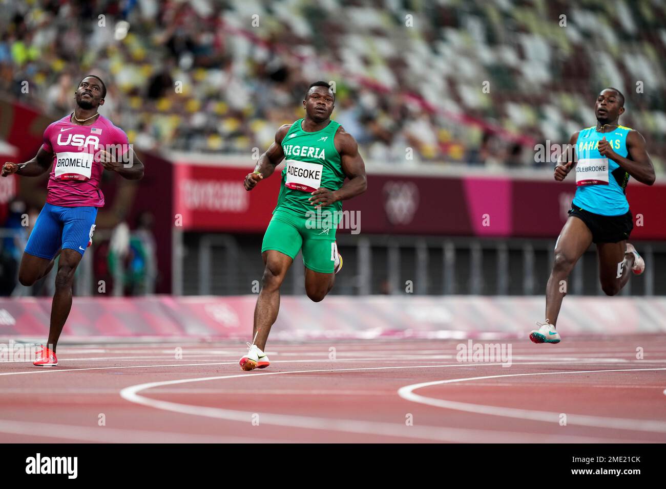 Enoch Adegoke, of Nigeria, center, wins a heat in the men's 100-meter ...