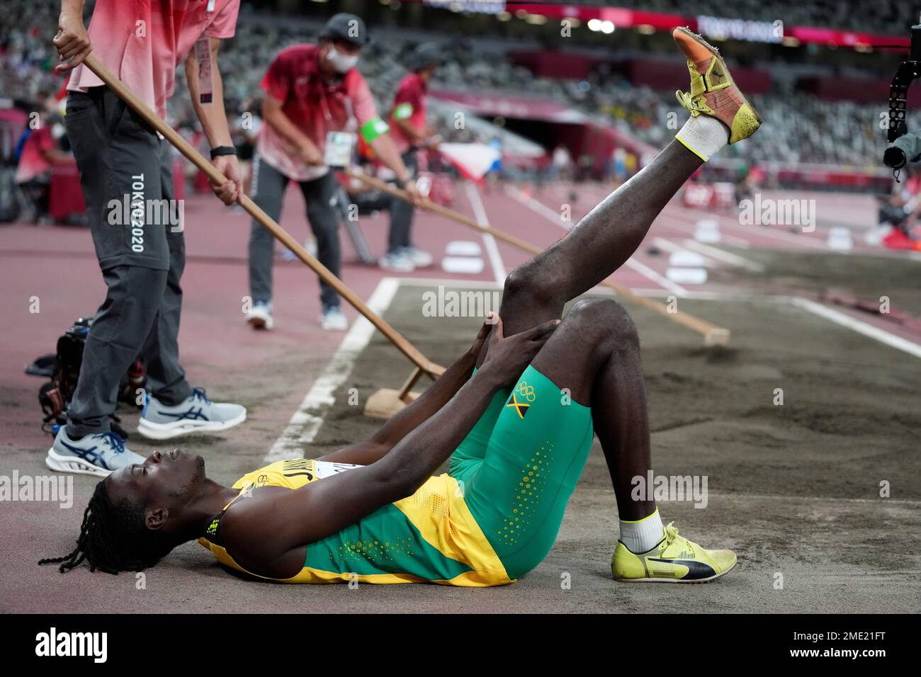 Tajay Gayle, of Jamaica, stretches his leg during the qualification ...