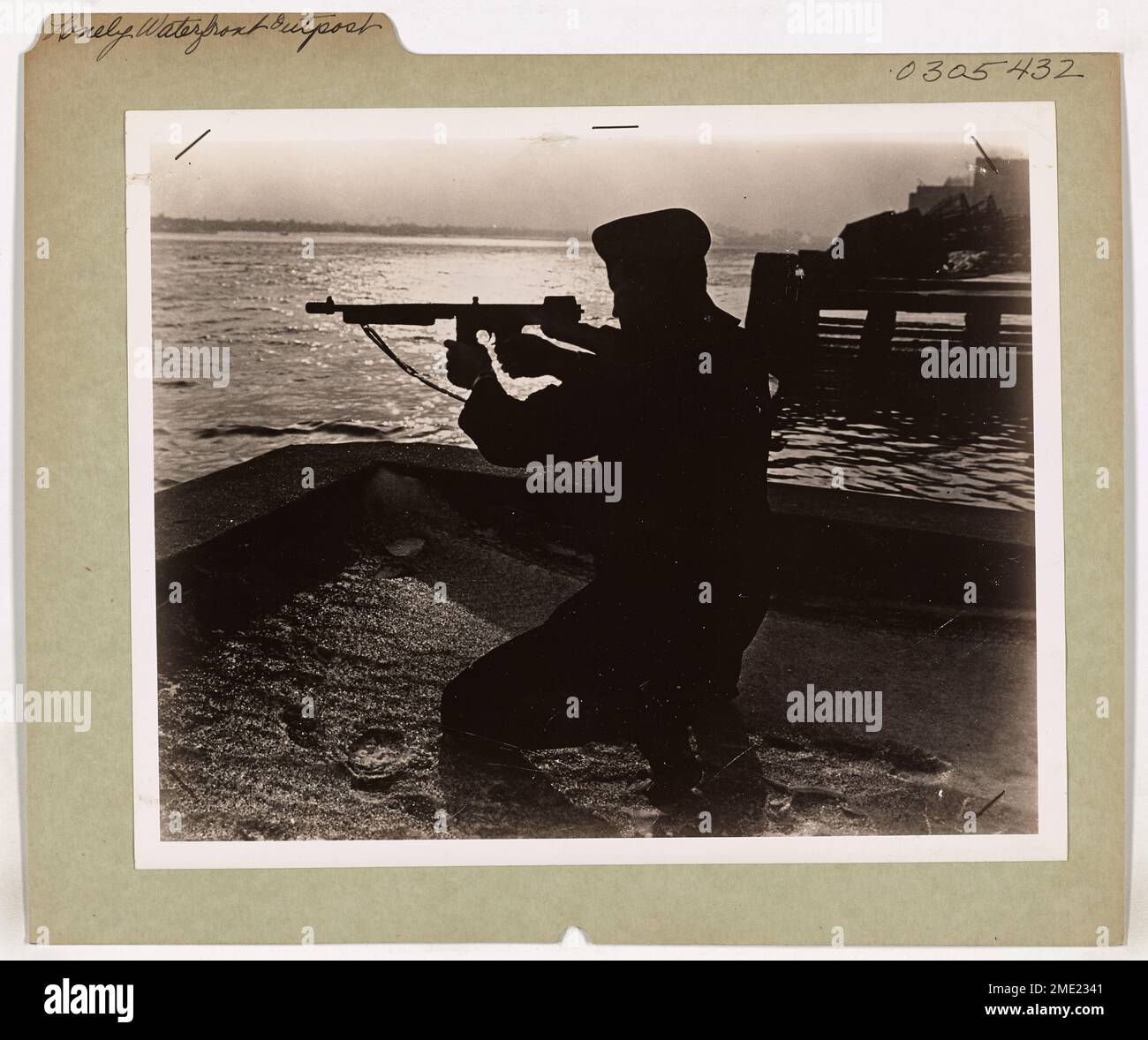 A Coast Guard sentry, armed with a machine gun, patrols a lonely ...