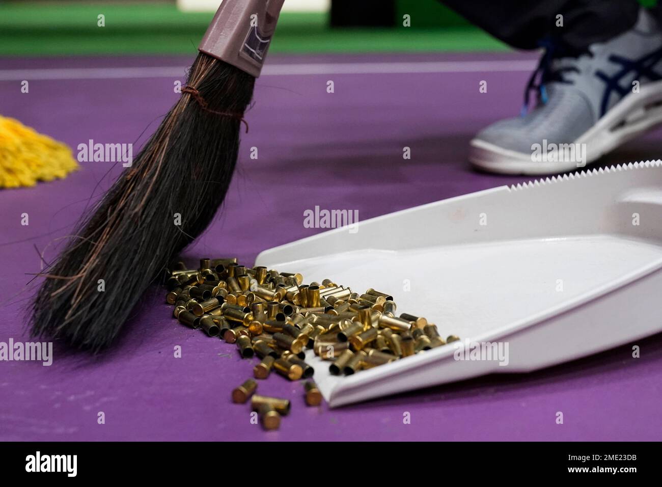 Empty .22 LR caliber shell casings are swept up after the women's 25 ...