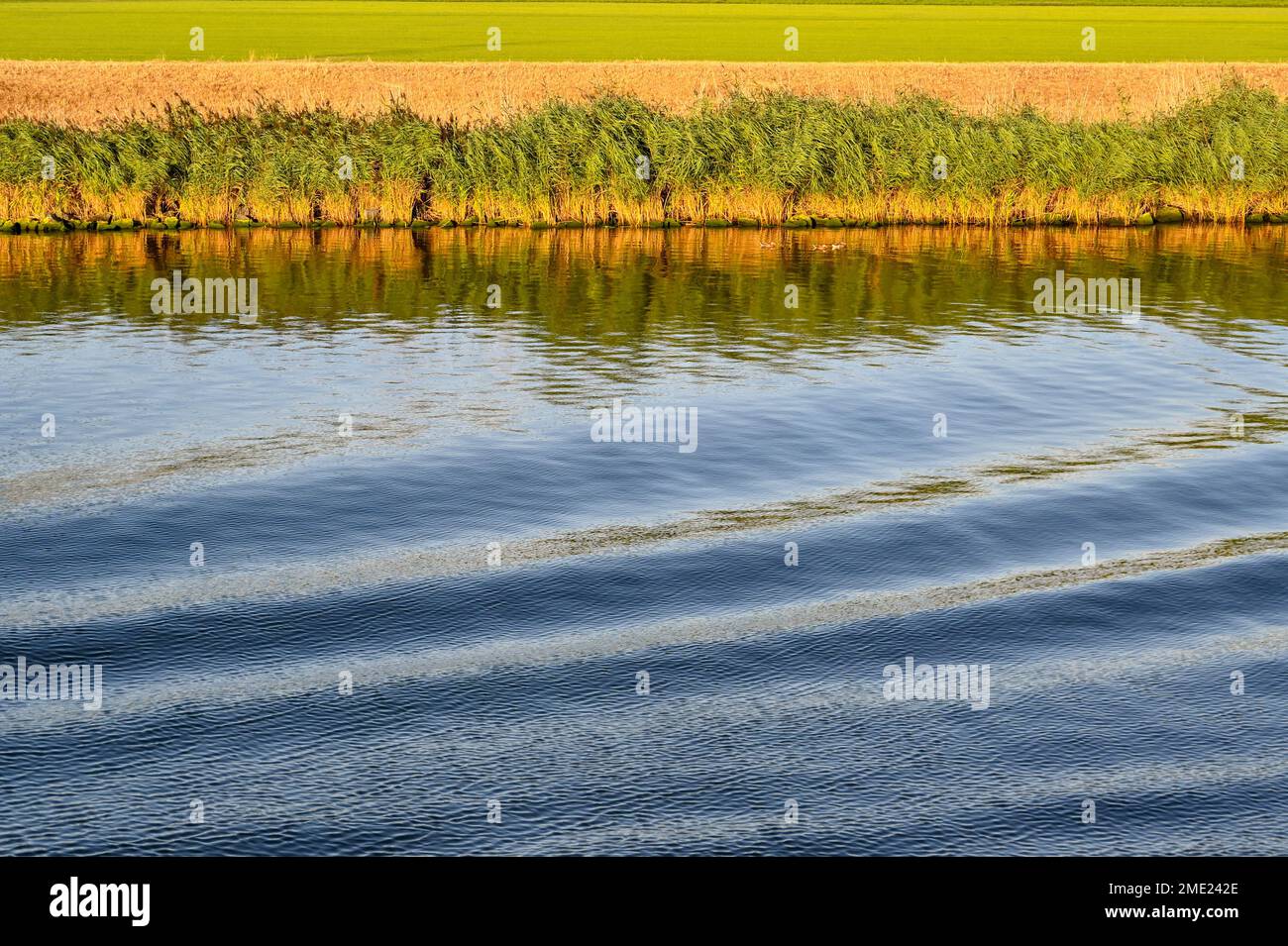 Scenic landscape view of a riverbank with wave pattern in water from ...
