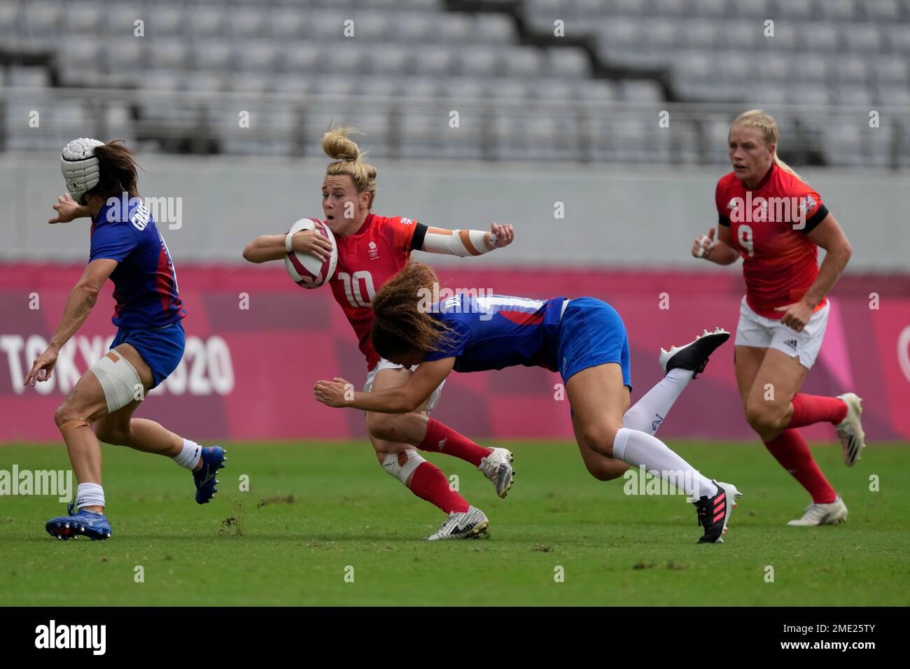 Britain's Megan Jones, center left, tries to evade a tackle by France's ...