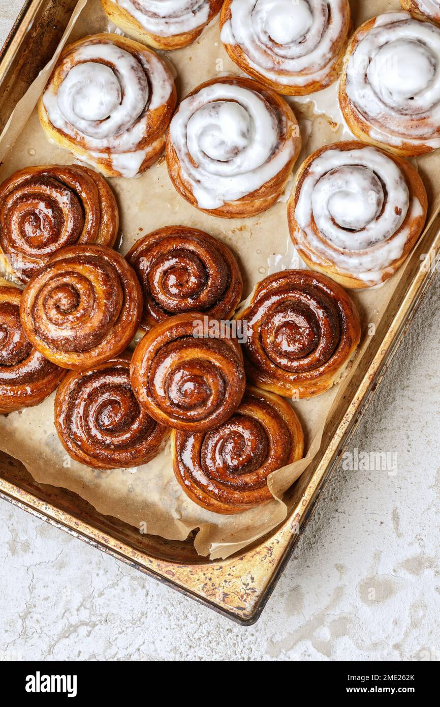 Freshly baked homemade Cinnamon rolls or Cinnamon buns on baking paper ...