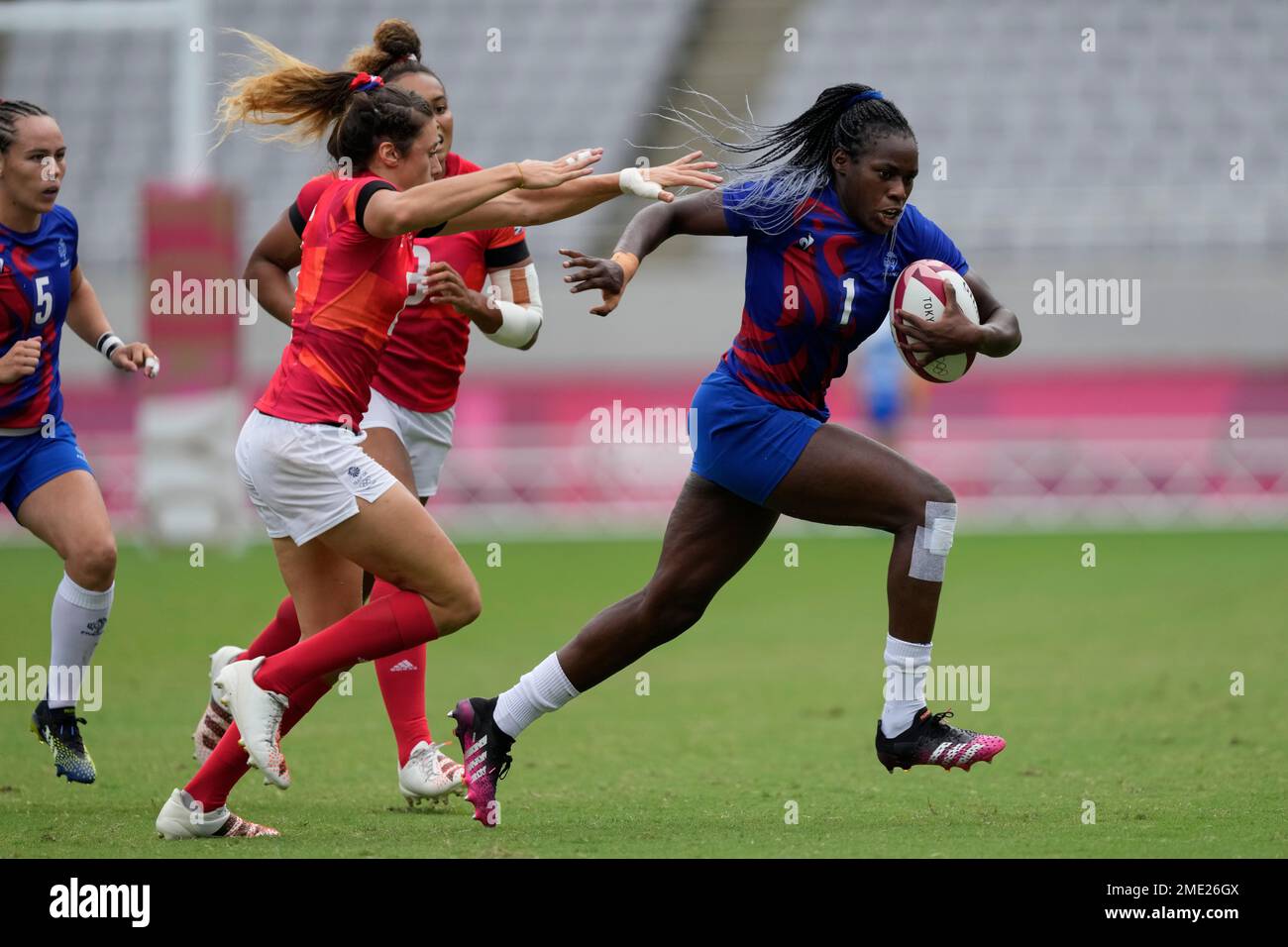 France's Seraphine Okemba runs with the ball, pursued by Britain's ...