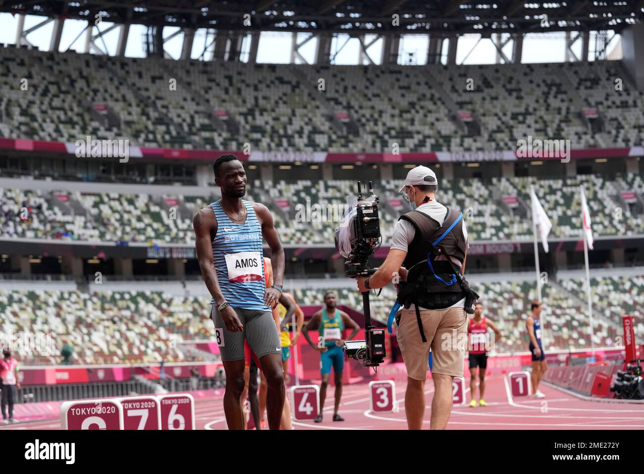 A cameraman films Nijel Amos, of Botswana, after he won a heat in the ...