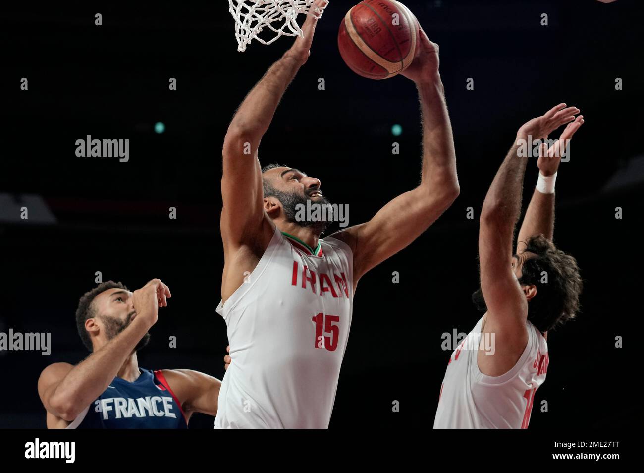 Iran's Hamed Haddadi (15), center, goes to the basket past France's ...