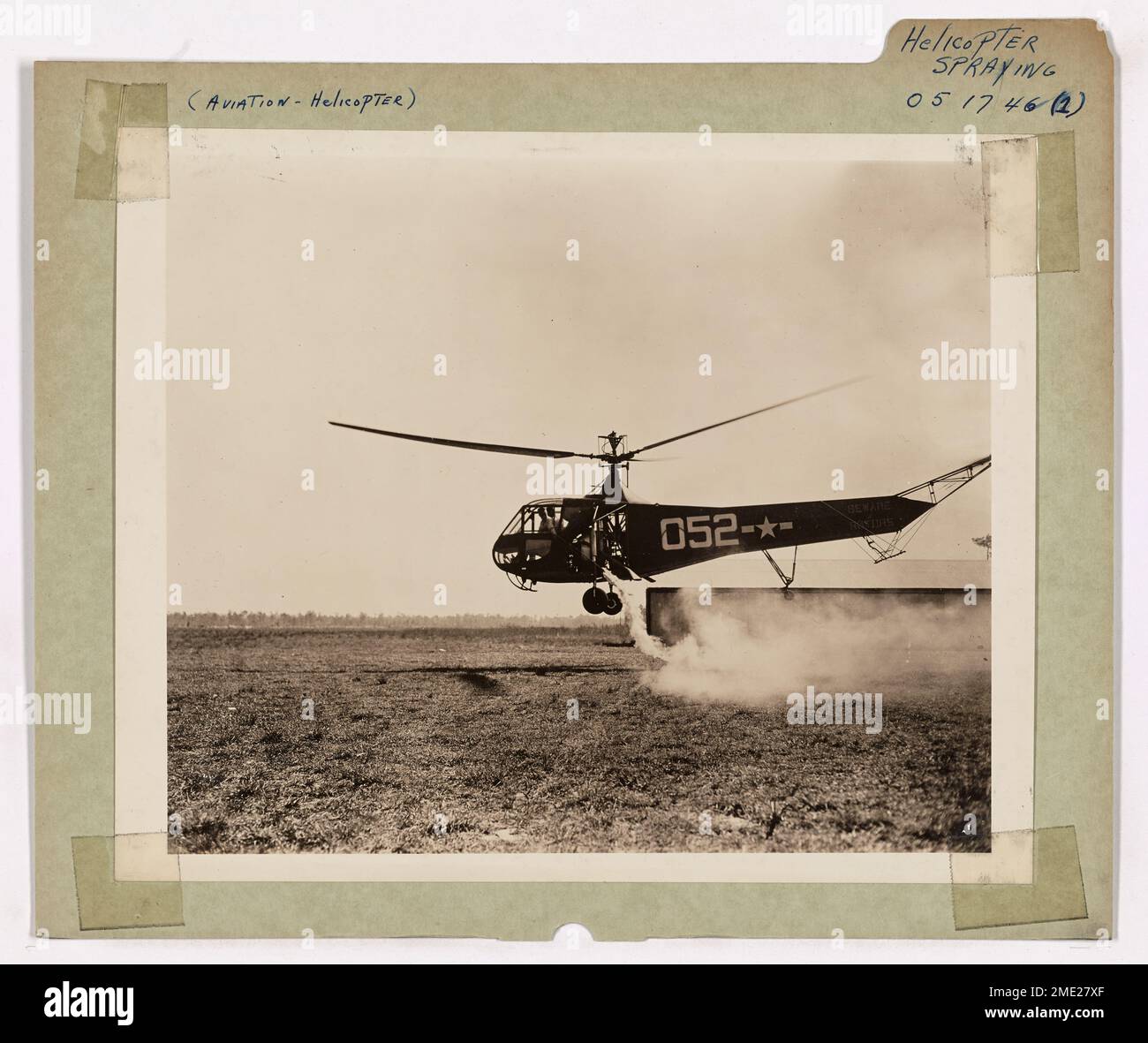 A helicopter conducts insecticide spraying tests in a field, assessing ...