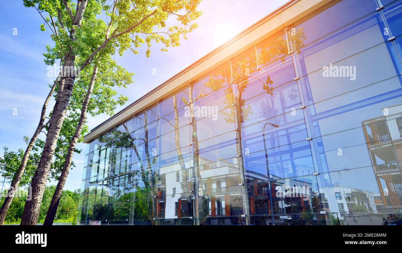 Eco architecture. Green tree and glass office building. The harmony of ...